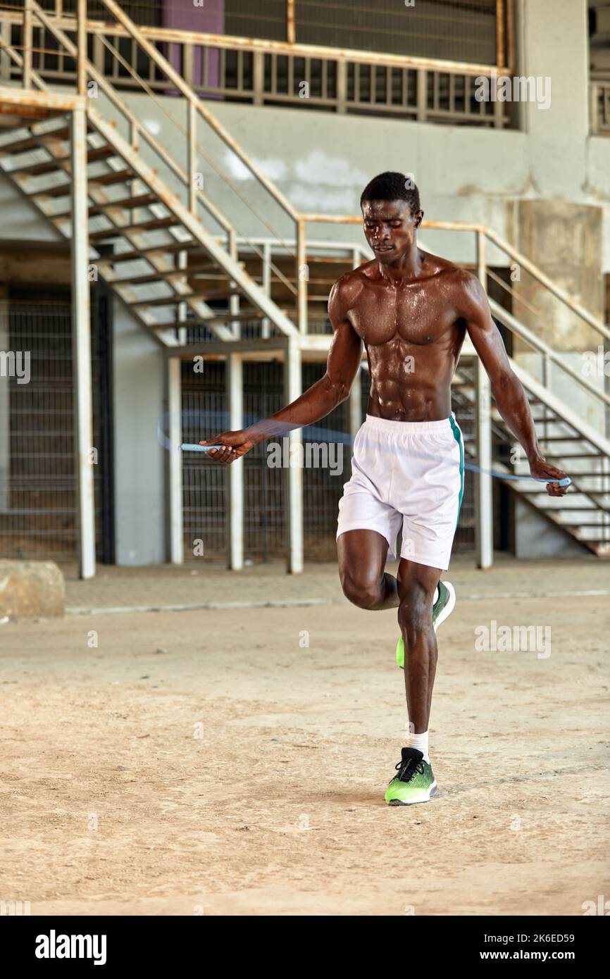 Muscular black man skipping rope. Portrait of muscular young man ...