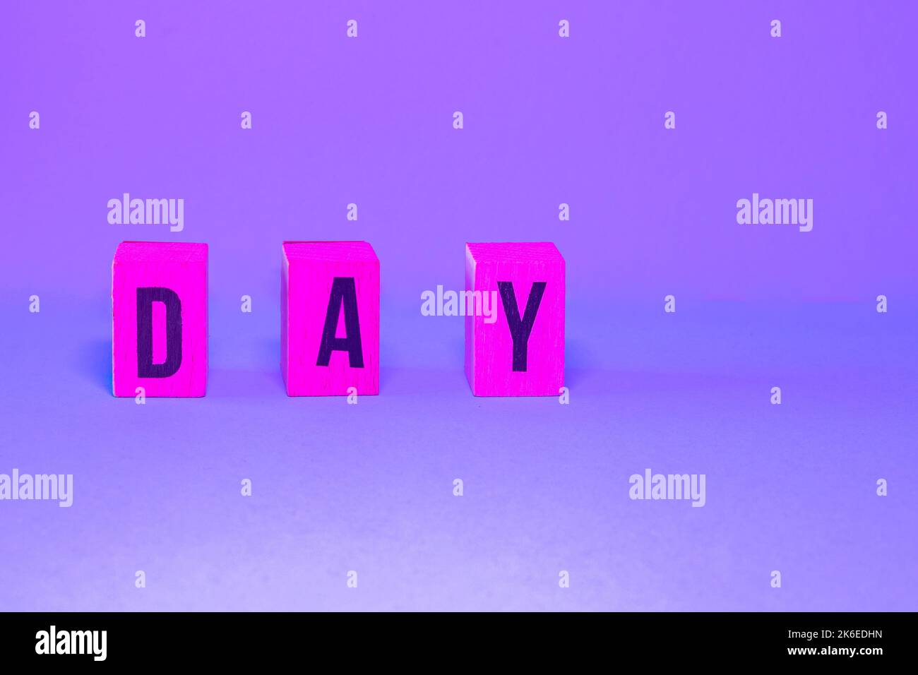 wooden letters with the word DAY on blue background with copy space ...