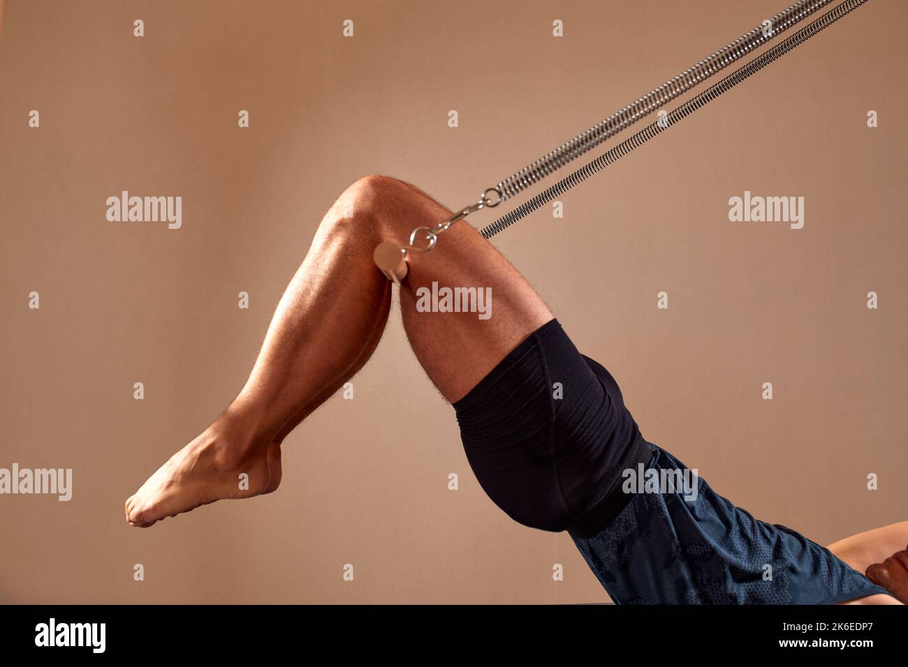 Handsome pilates male instructor performing stretching balance fitness ...