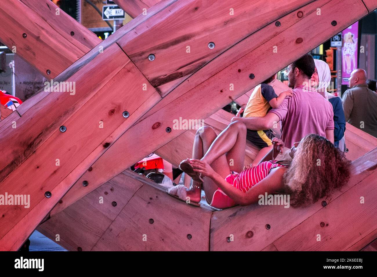 Times Square, New York City, woman stretched out on wooden sculpture ...