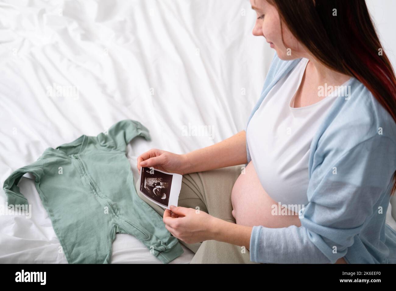 Top view cropped of pregnant woman looking ultrasound photo of fetus ...