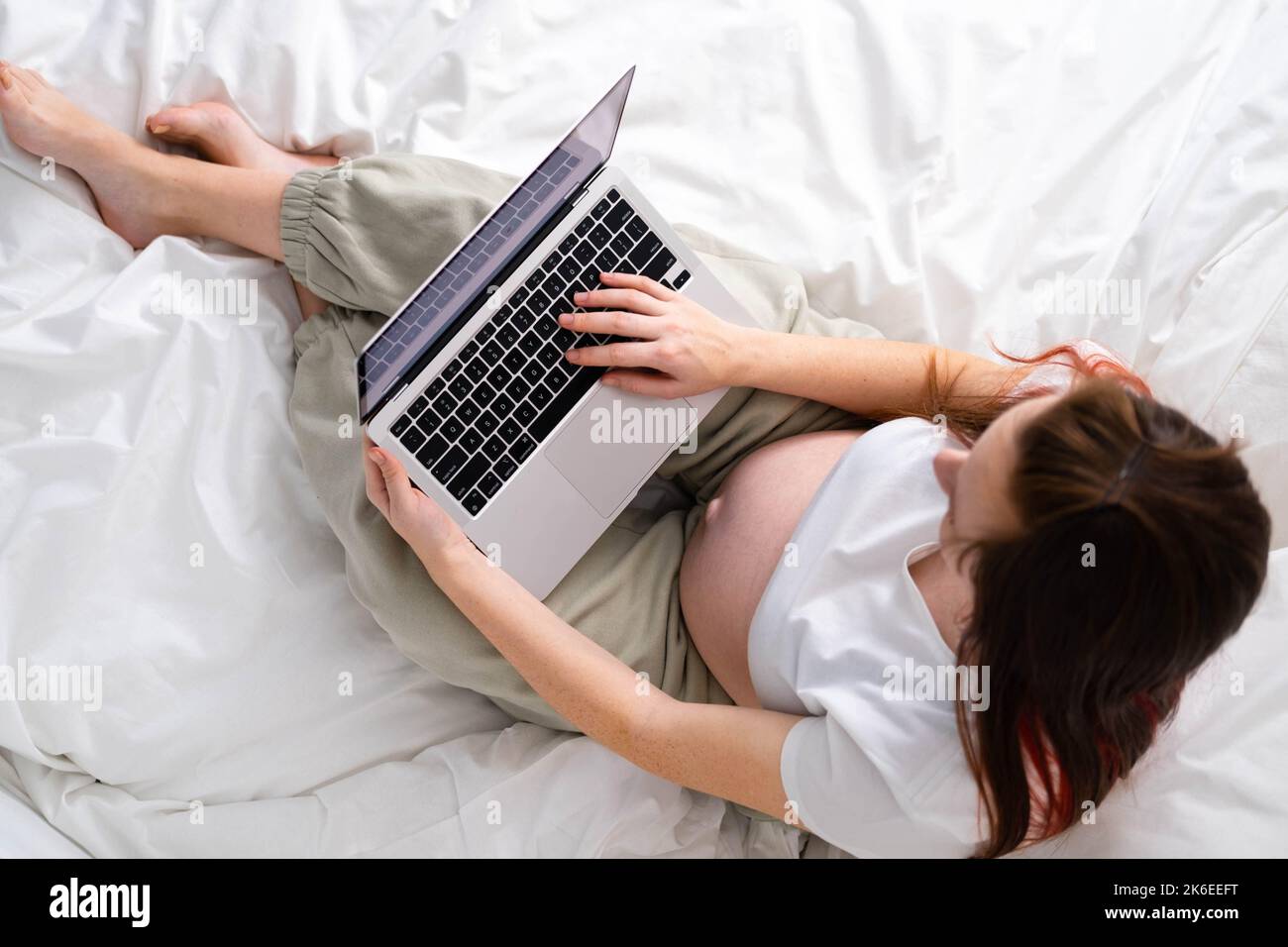 Top view Expectant mother working remotely online from home. Close up ...