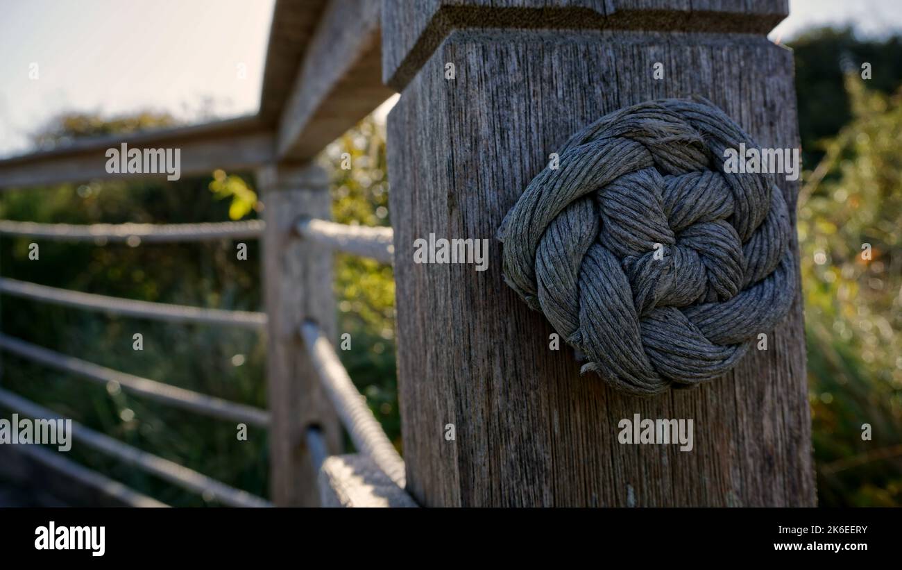 A knot on a wooden railing with a blurred background on the North Sea ...