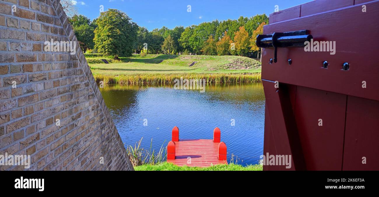 A landscape in Fortress Bourtange on the water with a red jetty in the ...