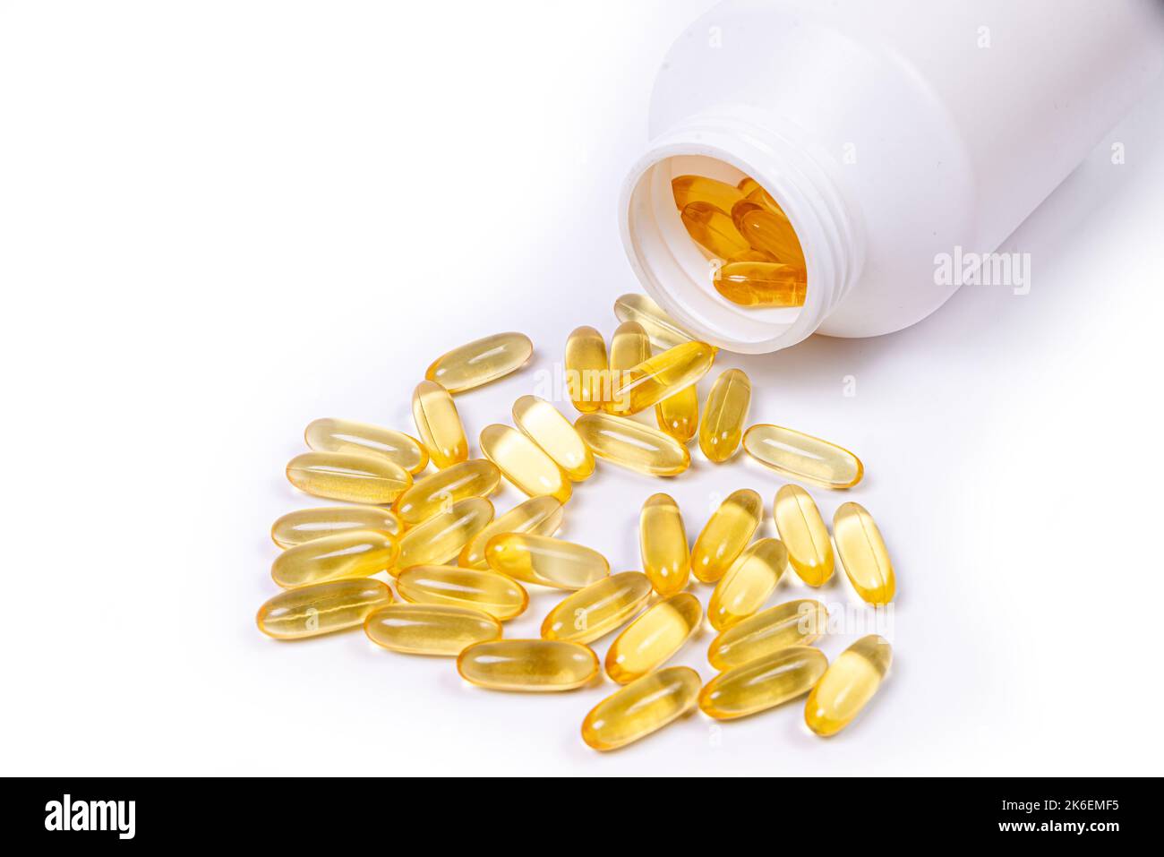 Medical white black orange pills spill out of a white jar on an ...