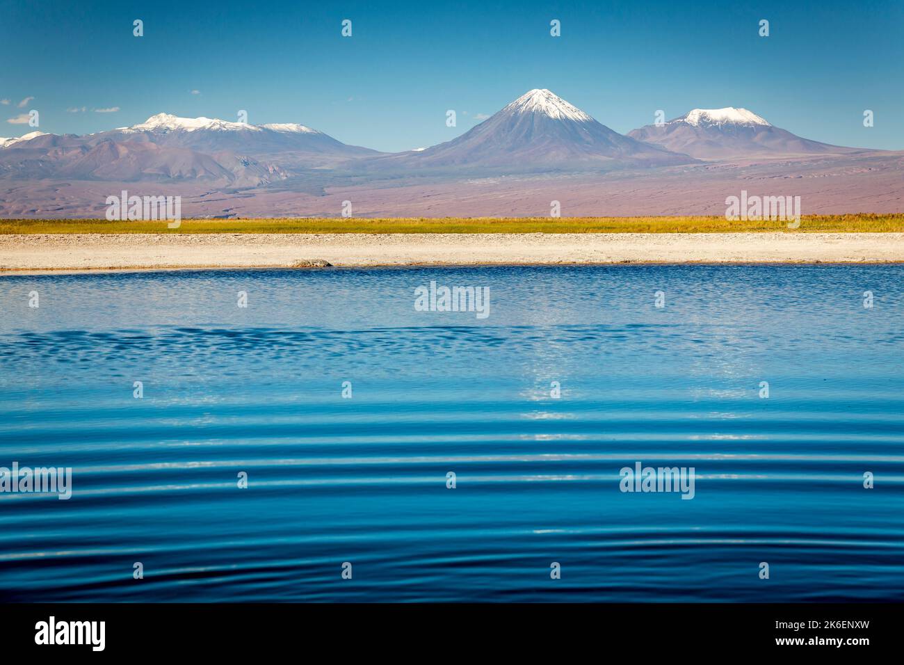 Volcanic landscape and salt lake reflection at sunset in Atacama Desert ...
