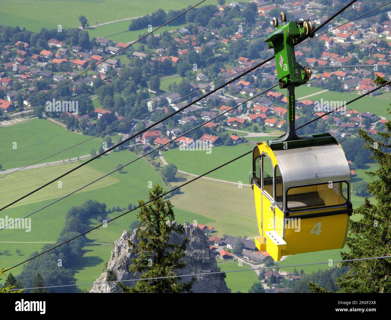 Yellow cable car of the mountain elevator Kampenwandbahn and view to ...