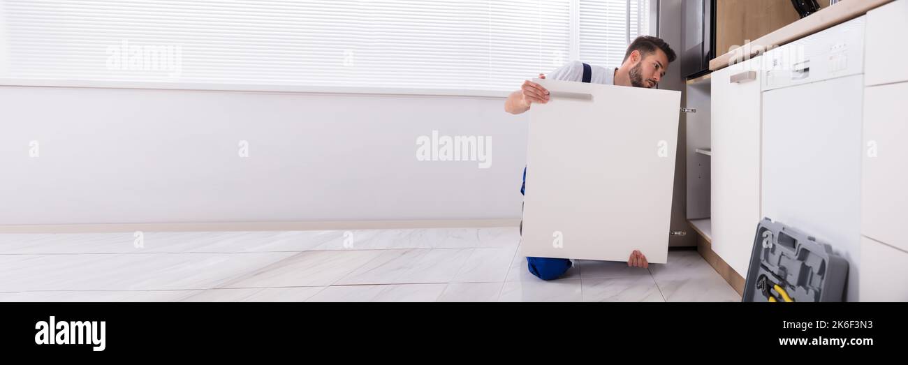 Carpenter Installing Kitchen Furniture. Maintenance And Fixing Stock ...