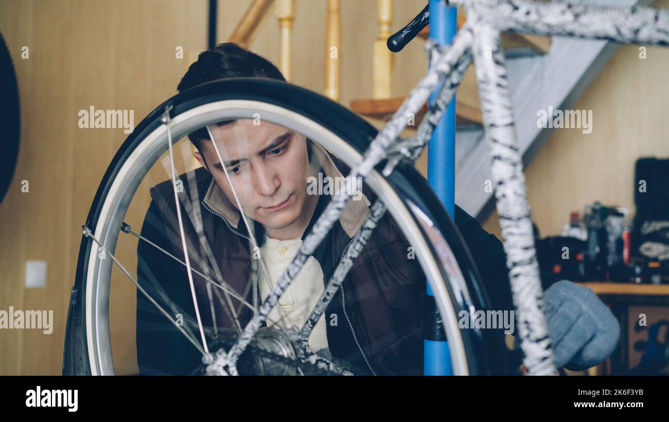 Professional bike repairman is busy fixing mechanism of bicycle wheel ... Professional bike repairman is busy fixing mechanism of bicycle wheel ...