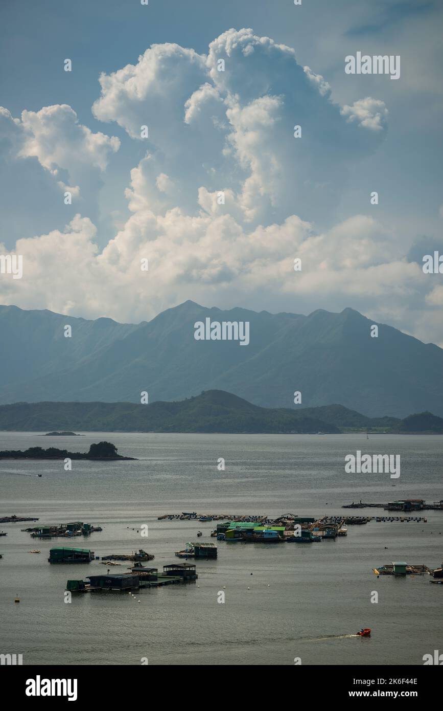 Summer storm clouds gather above the fish farms of Three Fathoms Cove ...