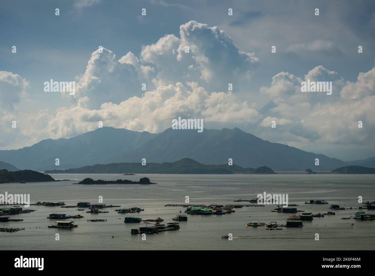 Summer storm clouds gather above the fish farms of Three Fathoms Cove ...