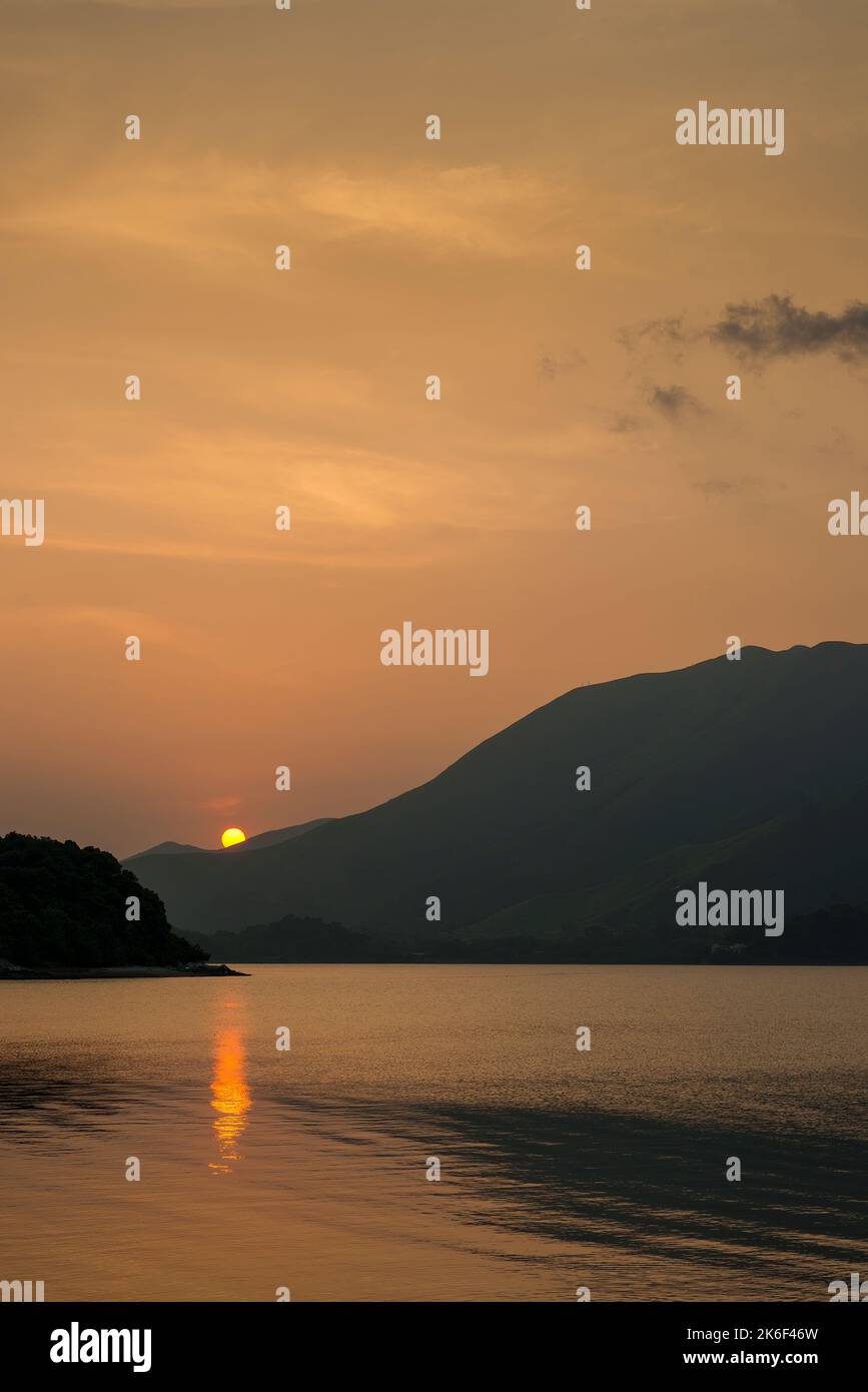 The setting sun reflected in the calm water of Starling Inlet, Plover ...