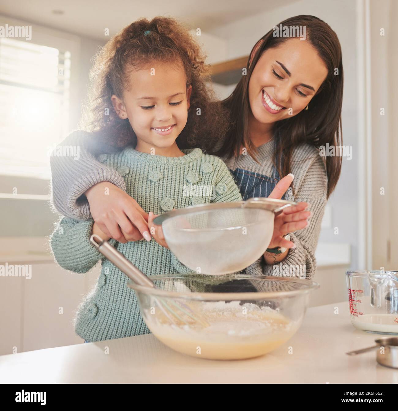 We want our cake light and fluffy. a mom baking with her daughter in ...