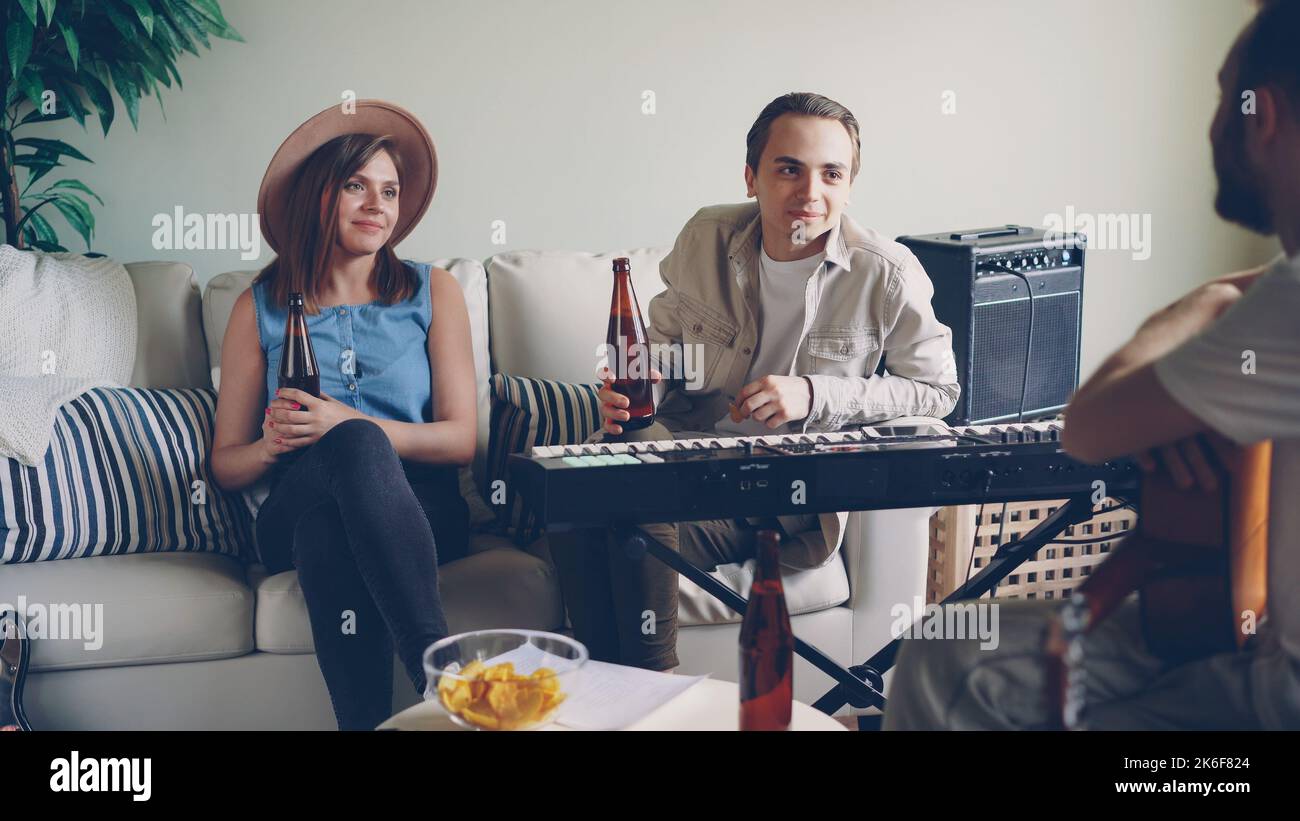 Members of musical band are talking and laughing during practice break ...