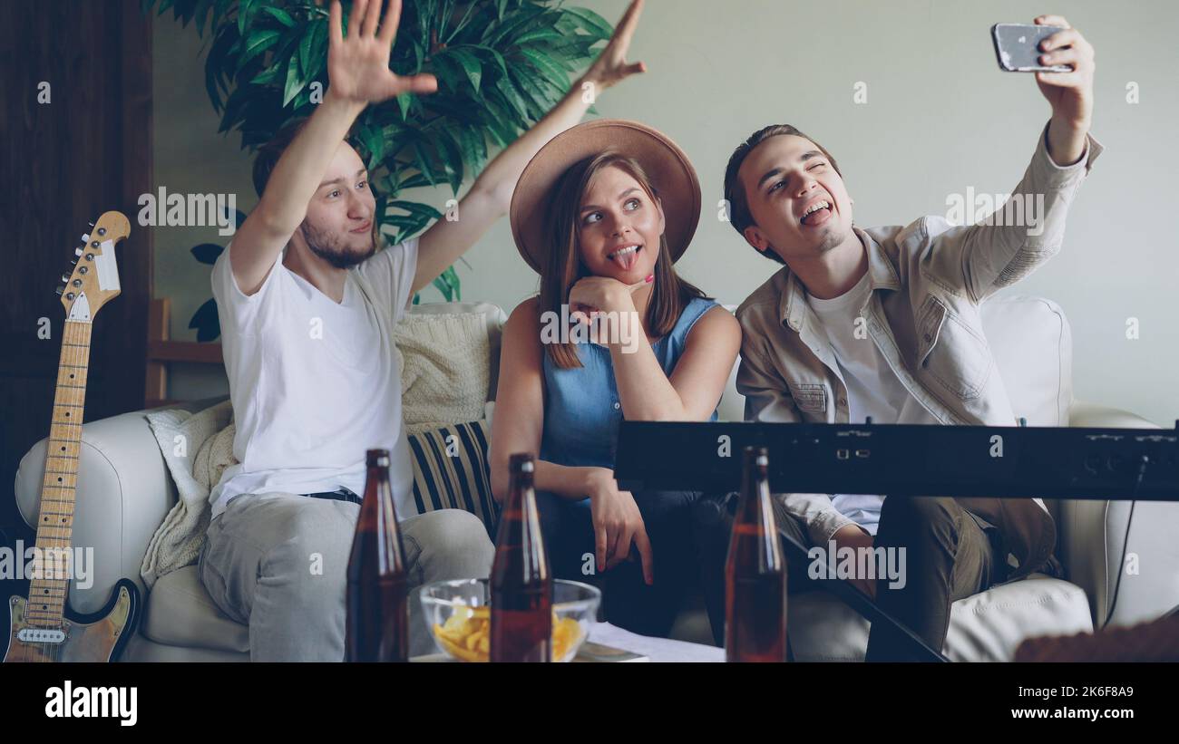 Playful young people from musical band are taking selfie with ...