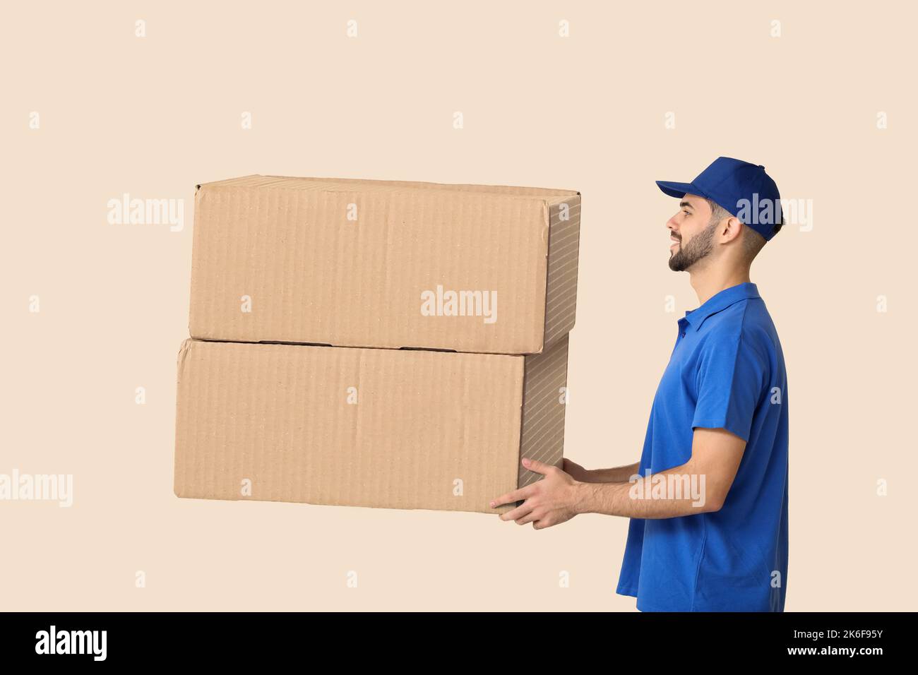 Delivery man with big boxes on light background Stock Photo - Alamy