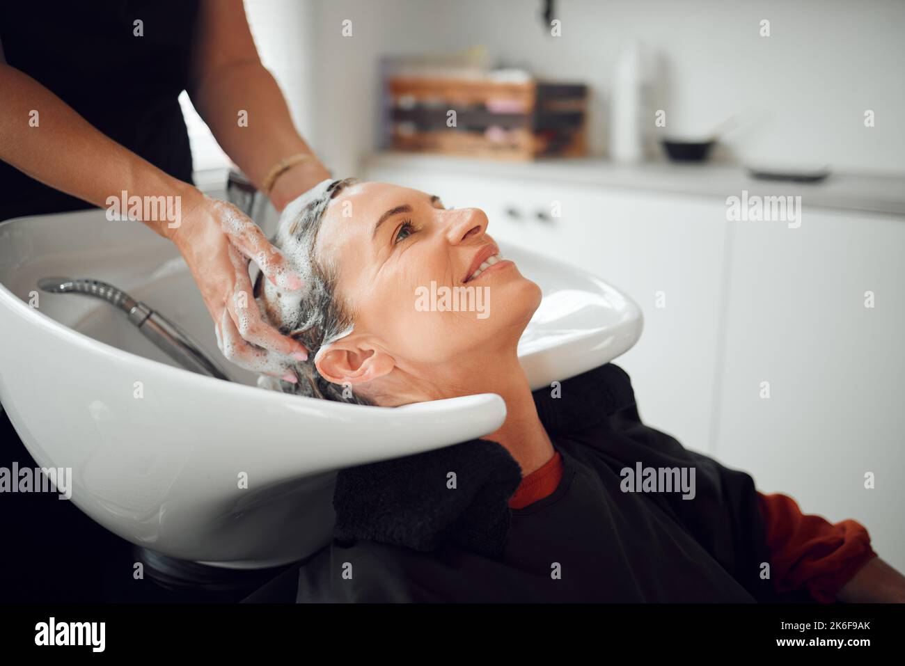 Shampoo, hairdresser and happy customer at a salon cleaning, massage ...