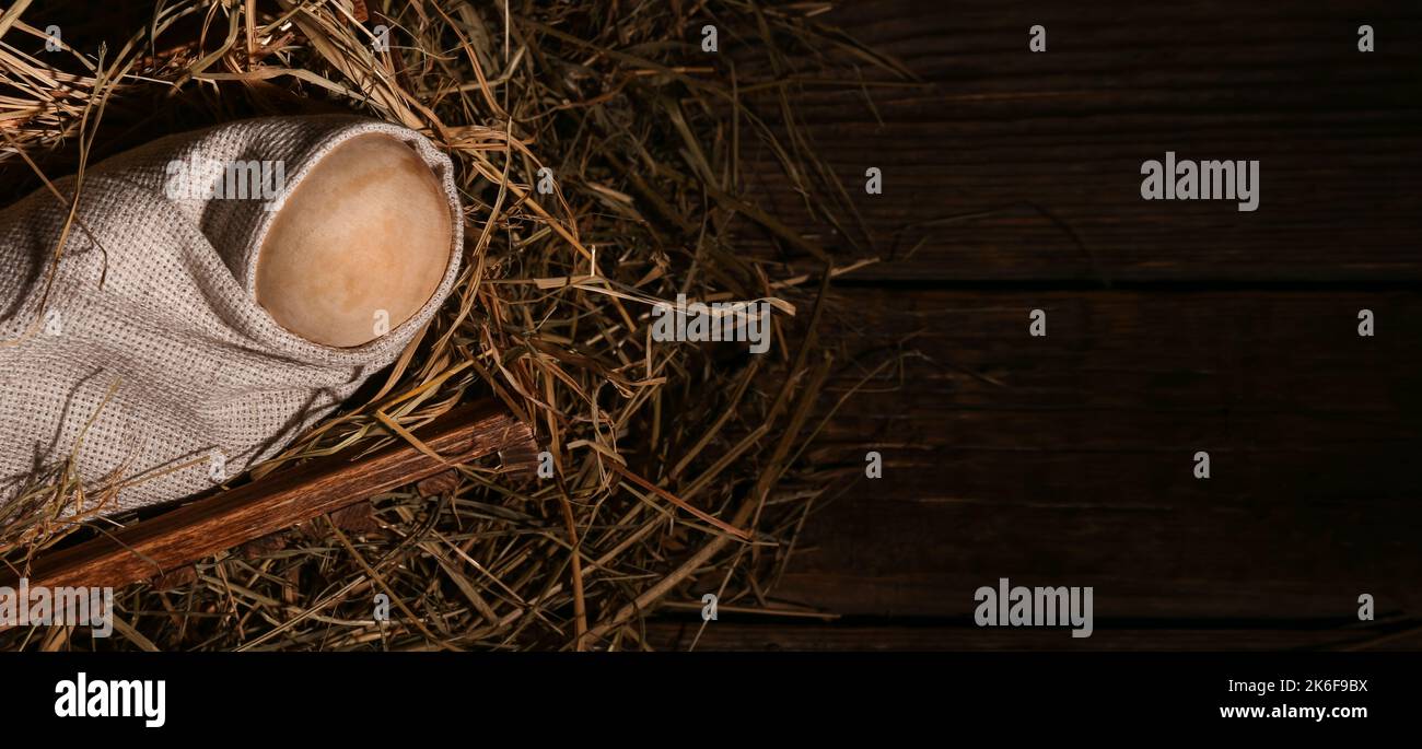 Manger with dummy of baby on dark wooden background with space for text ...
