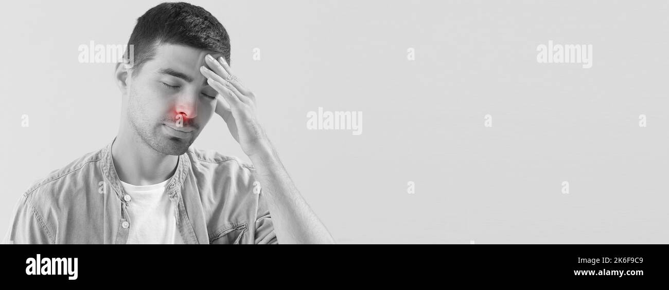 Young man with nosebleed on light background with space for text Stock ...