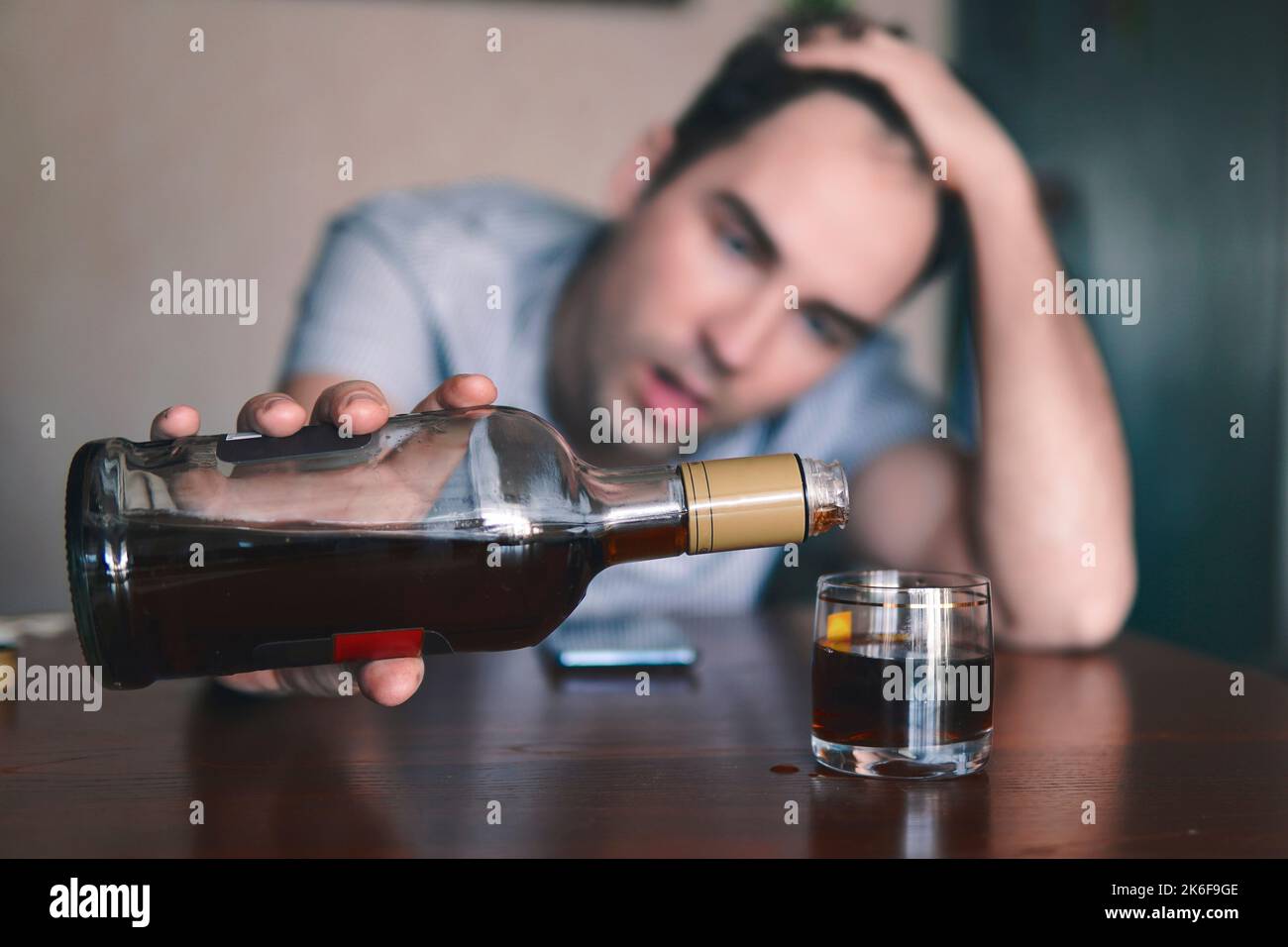 An alcoholic invokes a strong rum with a glass stack lying on the table ...