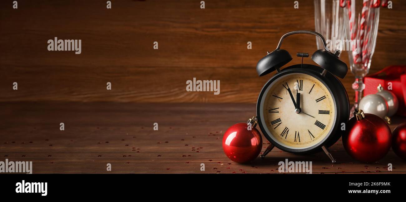 Alarm clock and New Year decor on wooden background. Banner for design ...