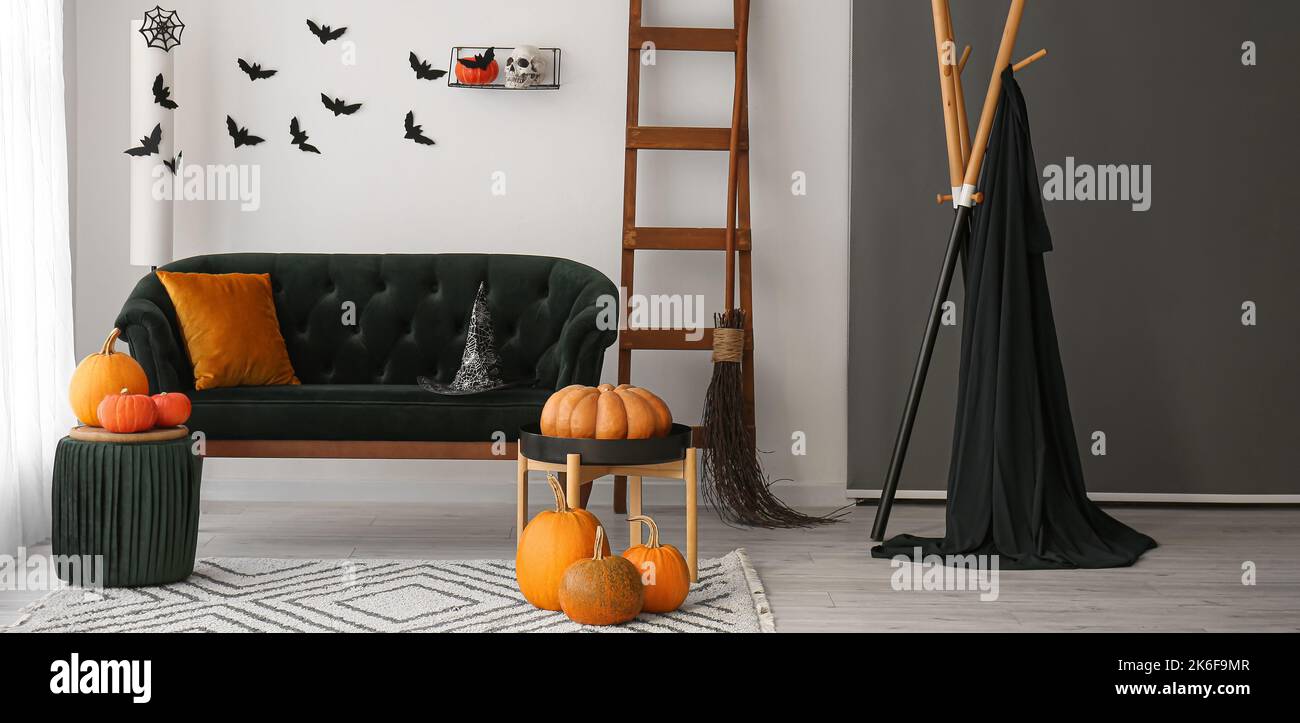 Interior of living room with sofa, ladder and pumpkins decorated for ...