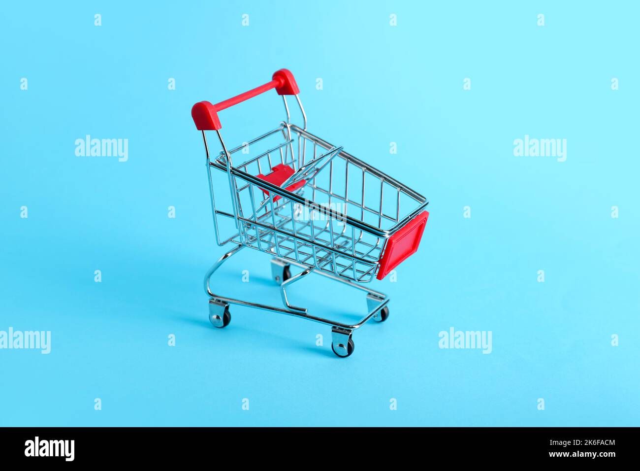 Red shopping cart on color background Stock Photo - Alamy