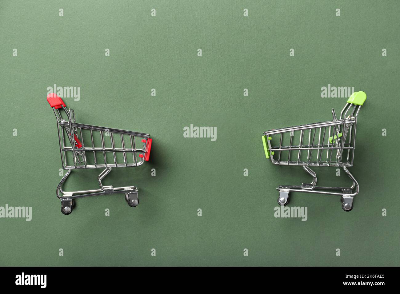 Empty shopping carts on green background Stock Photo - Alamy