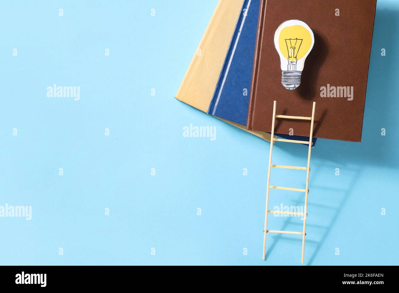 Ladder, books and light bulb on color background Stock Photo - Alamy