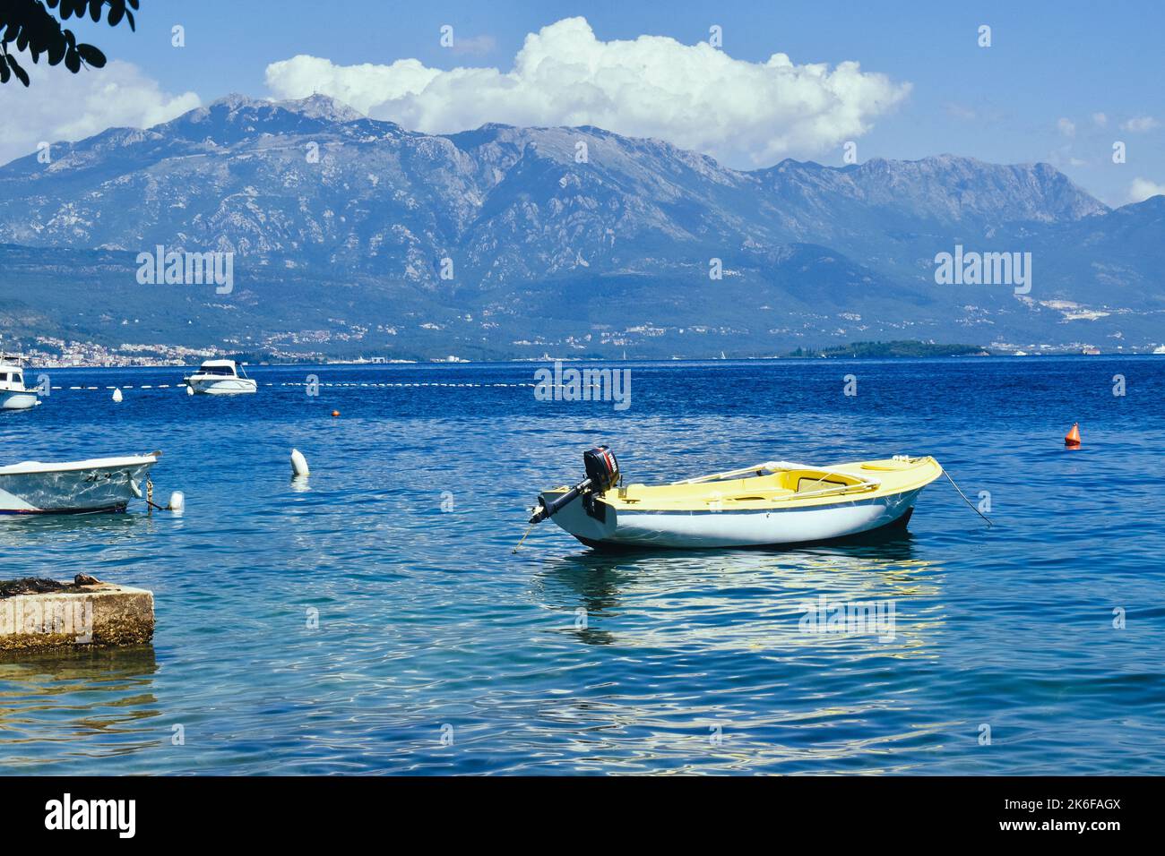 A white boat on the water surface with mountains in the background on a ...