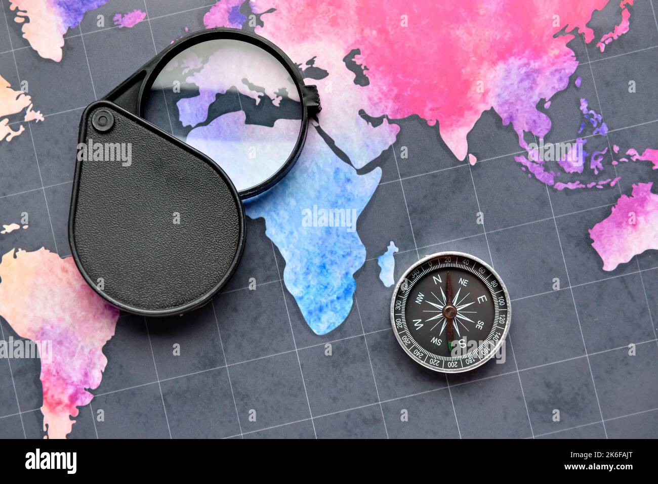 Magnifier and compass on world map Stock Photo - Alamy