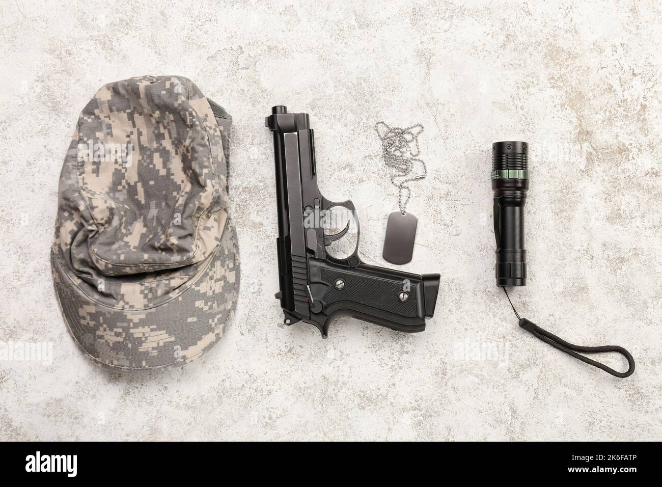 Military cap, gun, tag and flashlight on light background Stock Photo ...