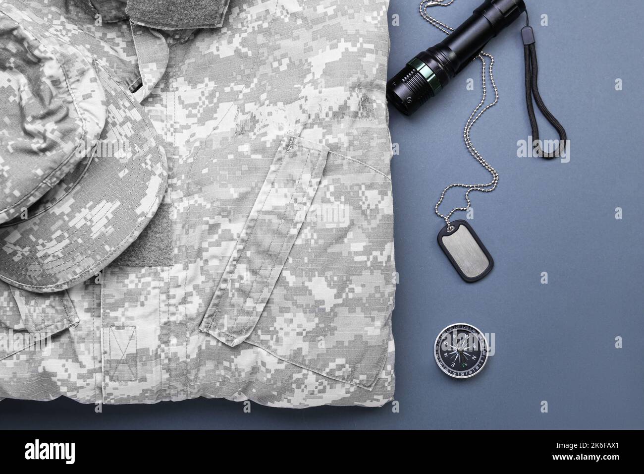 Military uniform, flashlight, tag and compass on grey background Stock ...