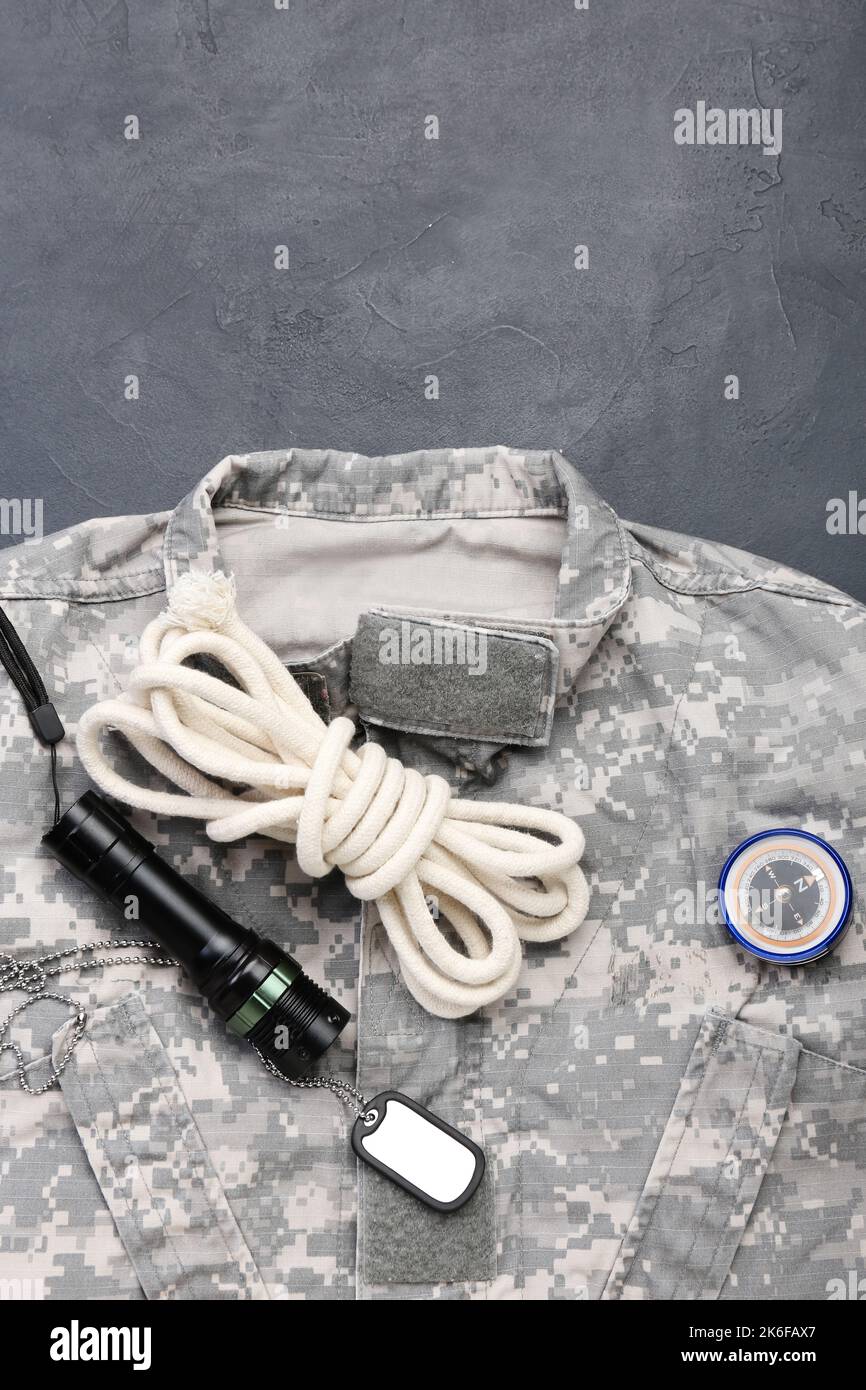 Military uniform, rope, flashlight, tag and compass on dark background ...