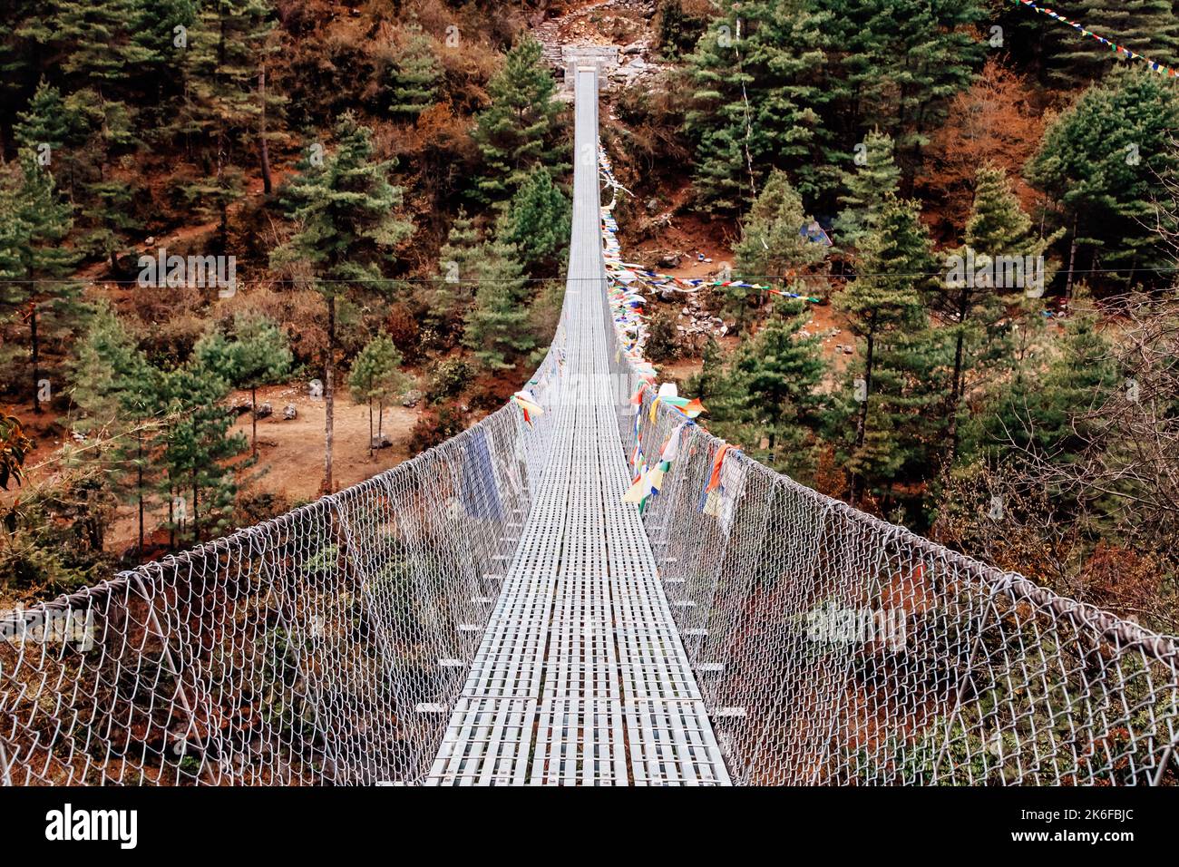 TTrekker crossing metal suspension bridge in Nepal, Himalayas Stock ...