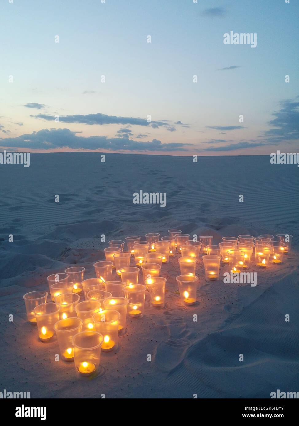A romantic evening in a deserted place. Candles on the sand in an ...