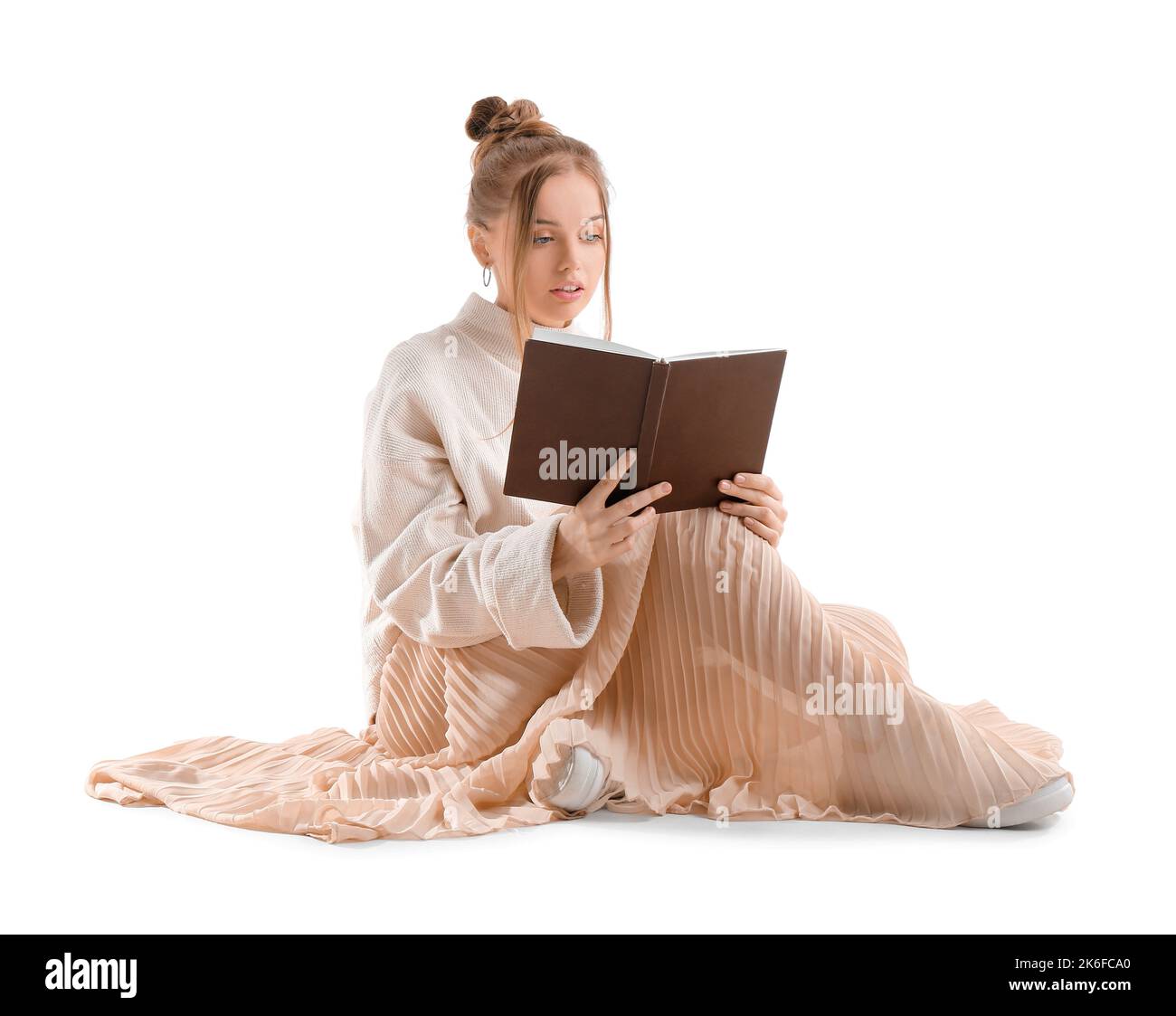 Pretty young woman reading book on white background Stock Photo - Alamy
