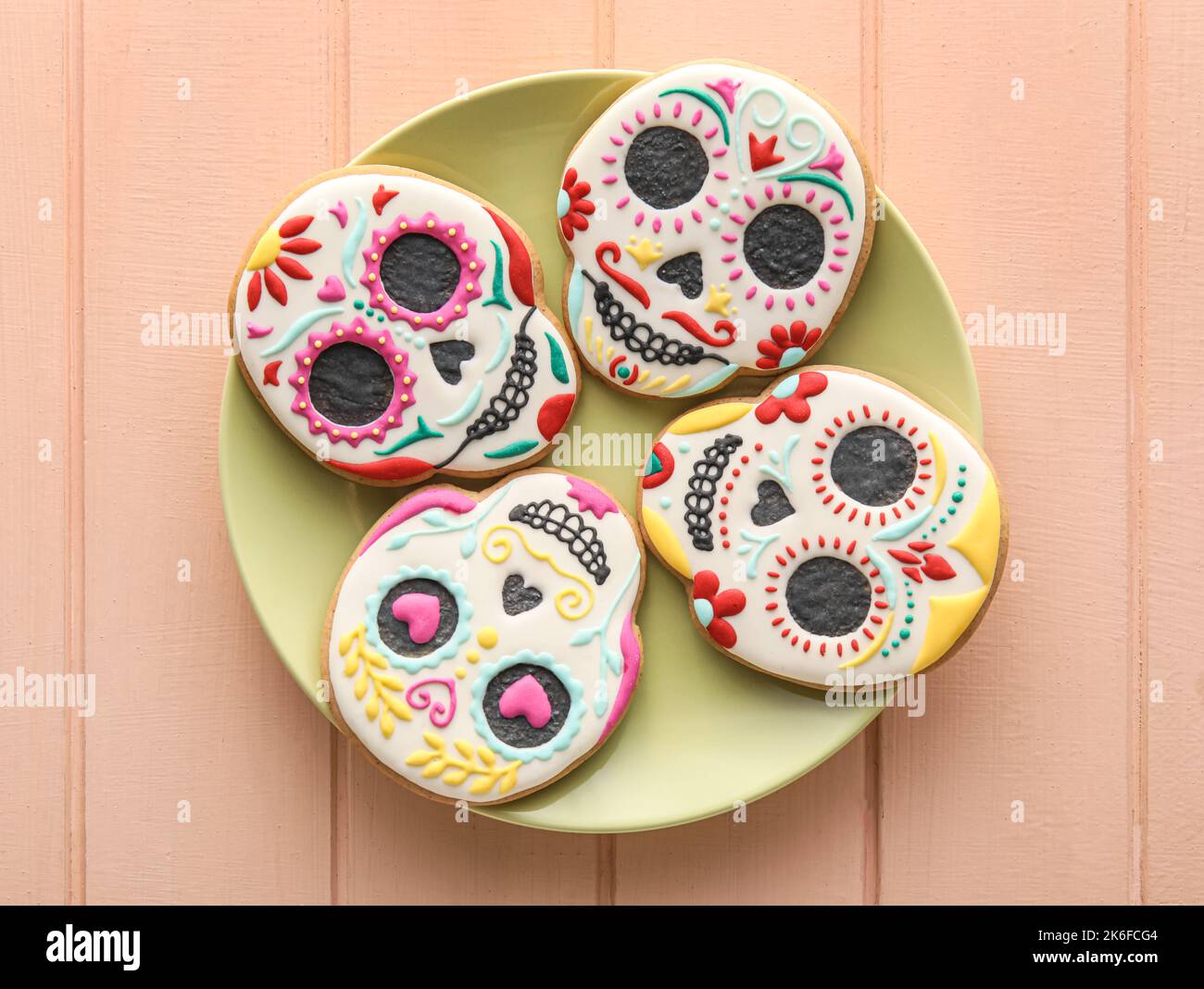 Plate with skull shaped cookies on color wooden background. El Dia de ...