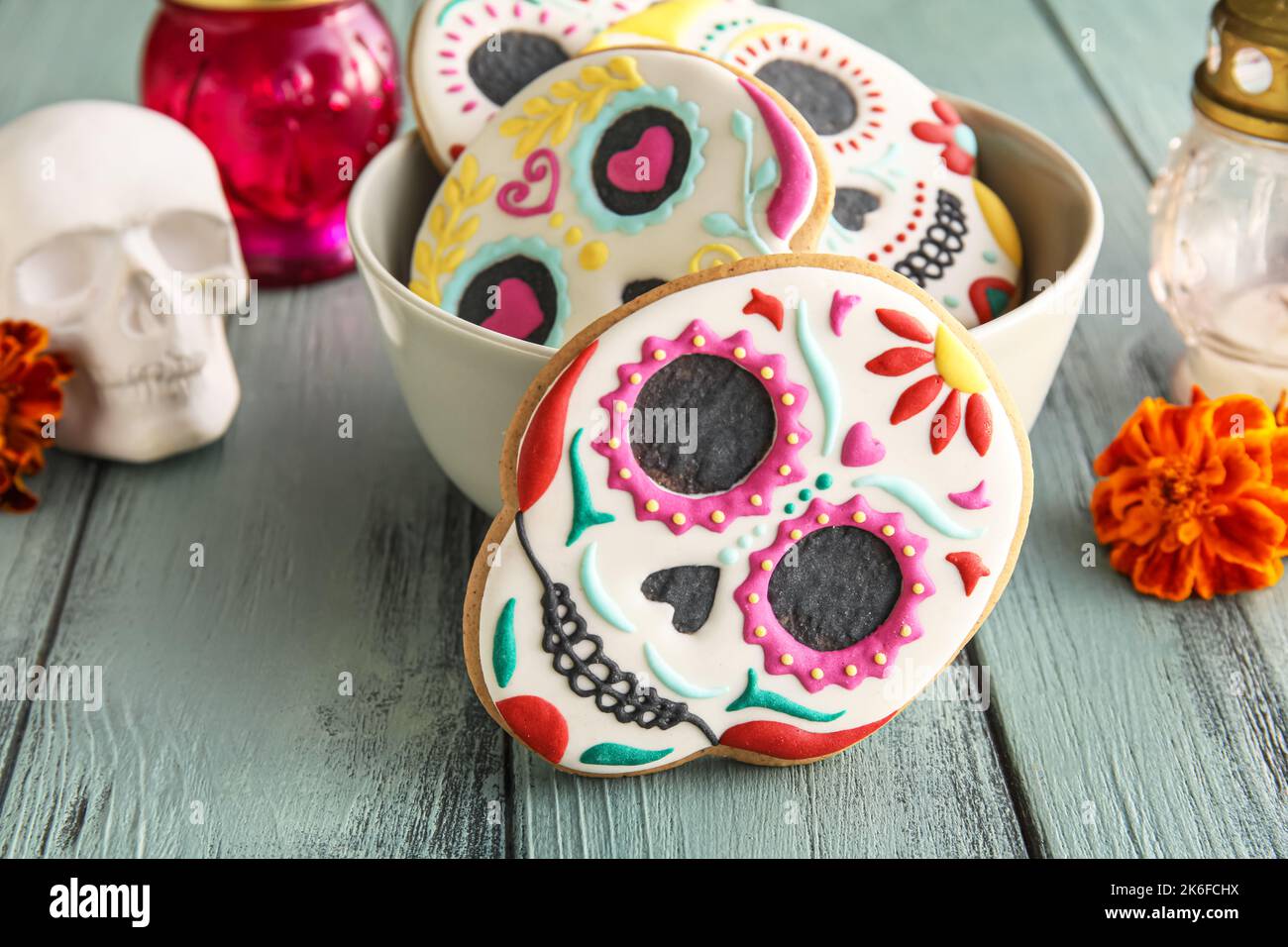 Bowl with skull shaped cookies on color wooden background, closeup. El ...