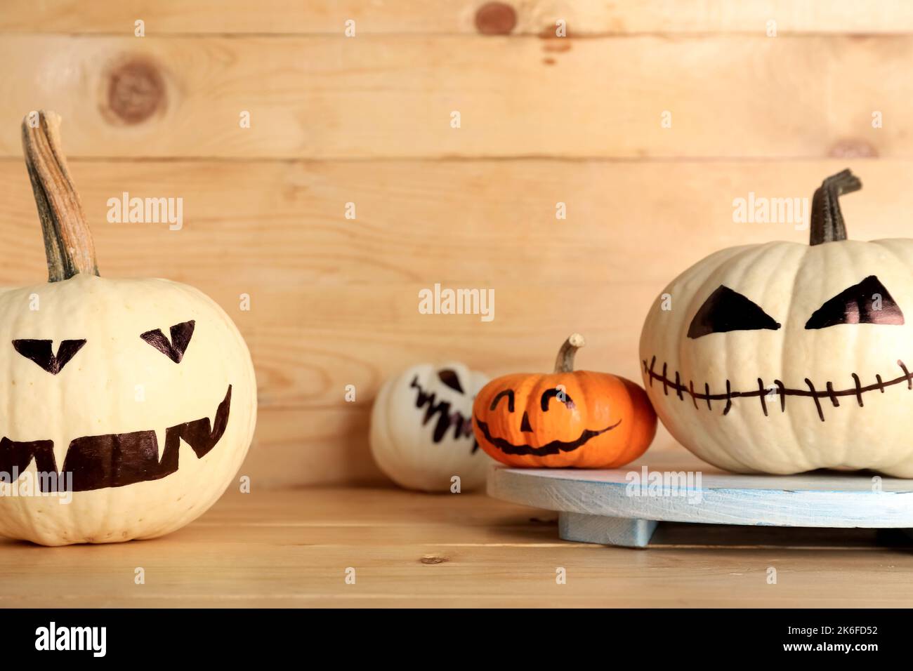 Different Halloween pumpkins on wooden background Stock Photo - Alamy