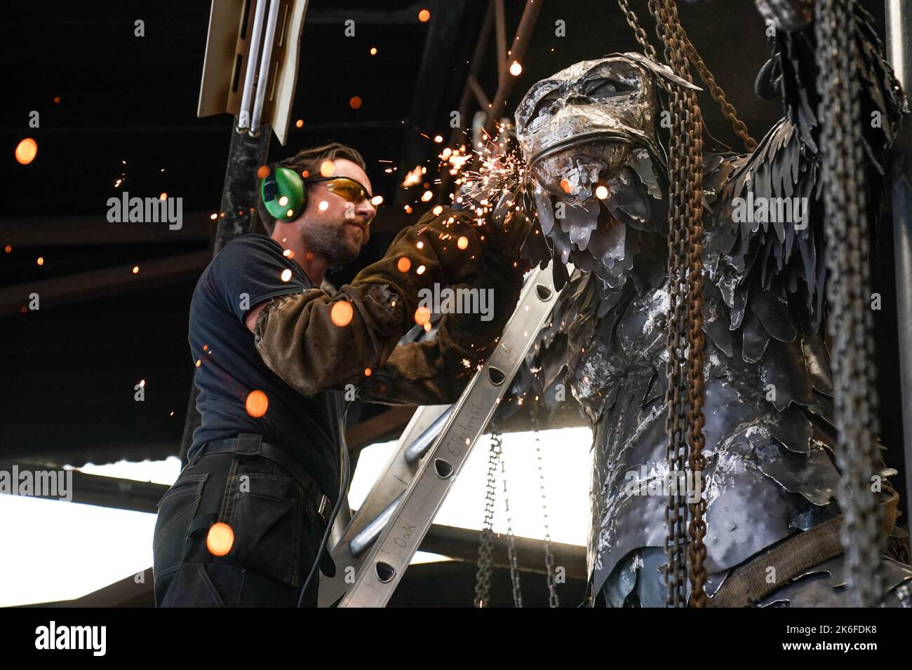 Sculptor Luke Perry applies finishing touches with an angle grinder to ...