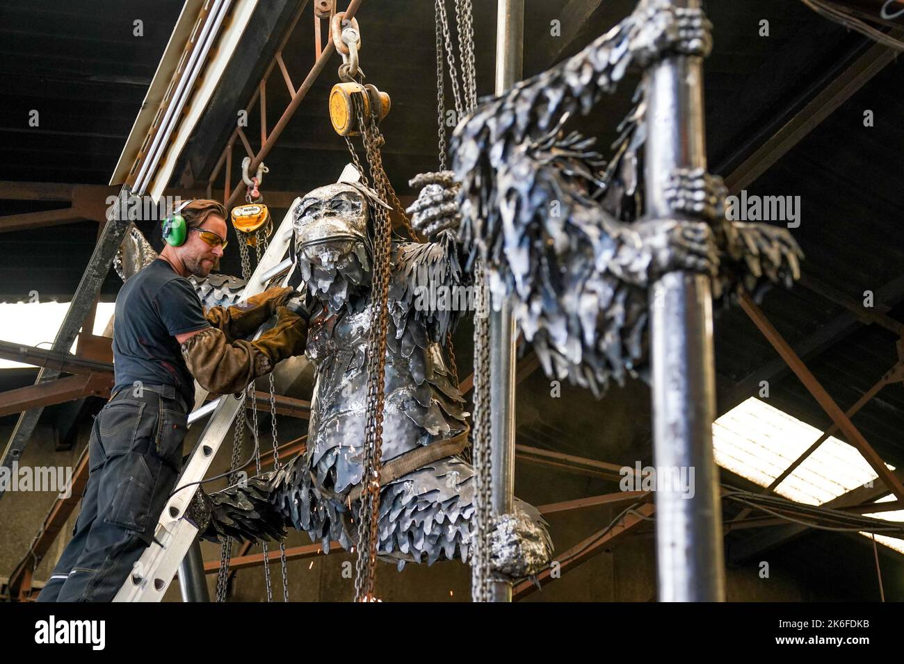 Sculptor Luke Perry applies finishing touches with an angle grinder to ...