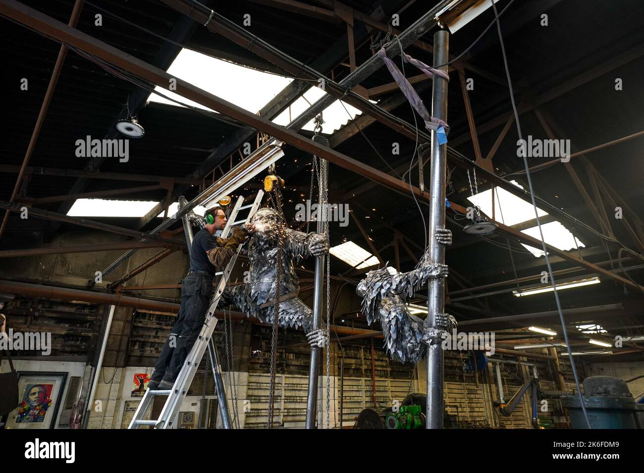 Sculptor Luke Perry applies finishing touches with an angle grinder to ...