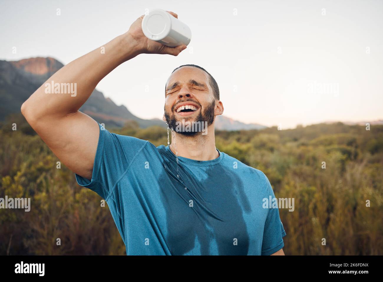 Sports man splash water bottle on face in nature hiking, running or ...