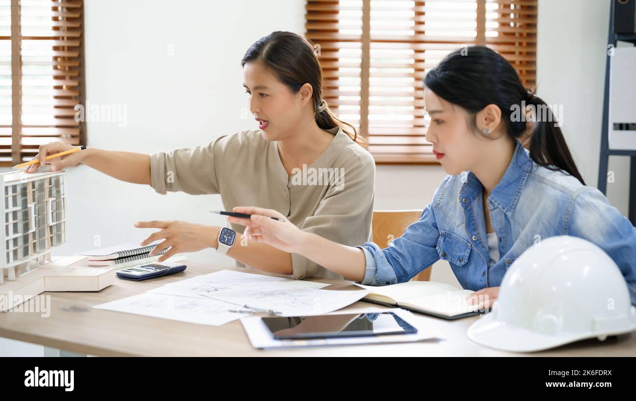 Concept of engineering consulting, Two female engineers pointing and ...
