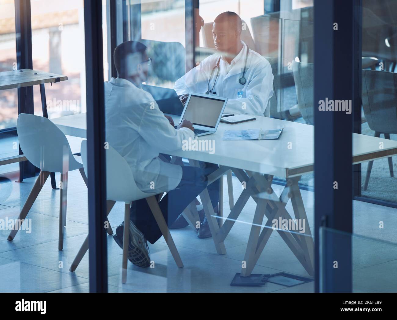 Doctors, men and laptop in hospital meeting for surgery planning, insurance application or ...