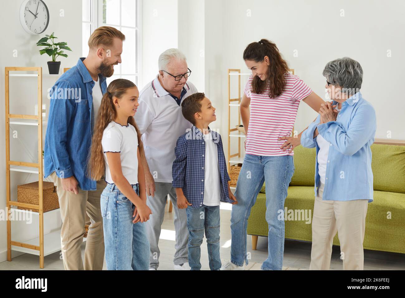 Happy mother together with rest of family standing in living room and ...