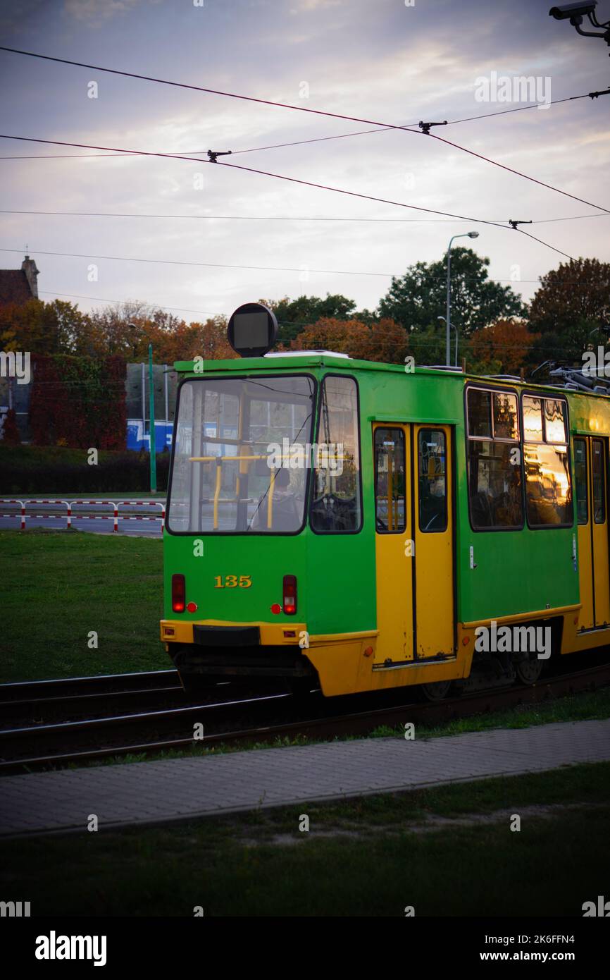 A vertical shot of green and yellow public transport tram in the Zawady ...