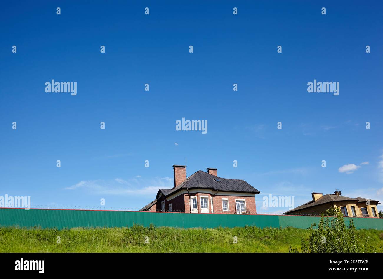 Facade of a European suburban buildings. Metal fence and house against ...