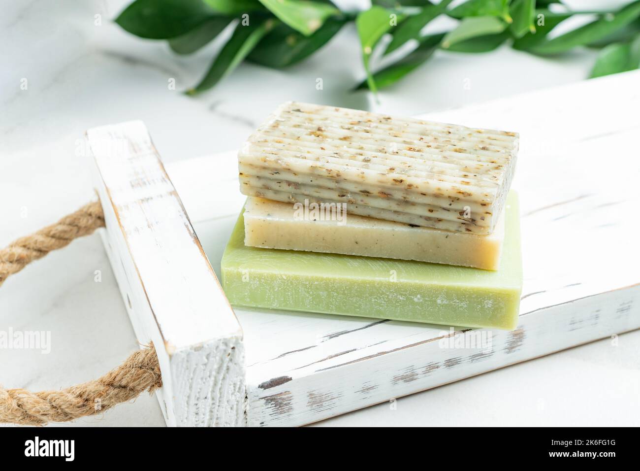 Tray with natural handmade soap on white table. Three different types ...